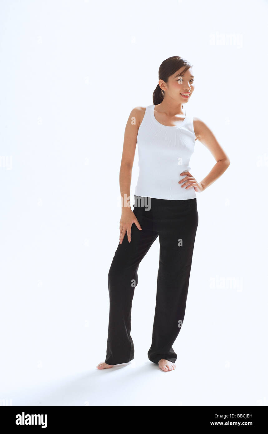 Woman standing with hands on hip, looking at camera Stock Photo - Alamy