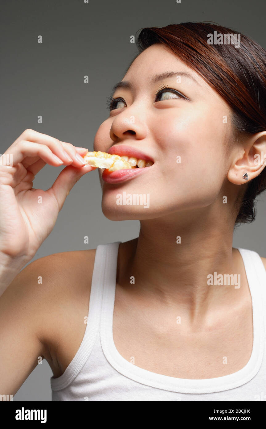 Woman eating an orange, side view Stock Photo - Alamy