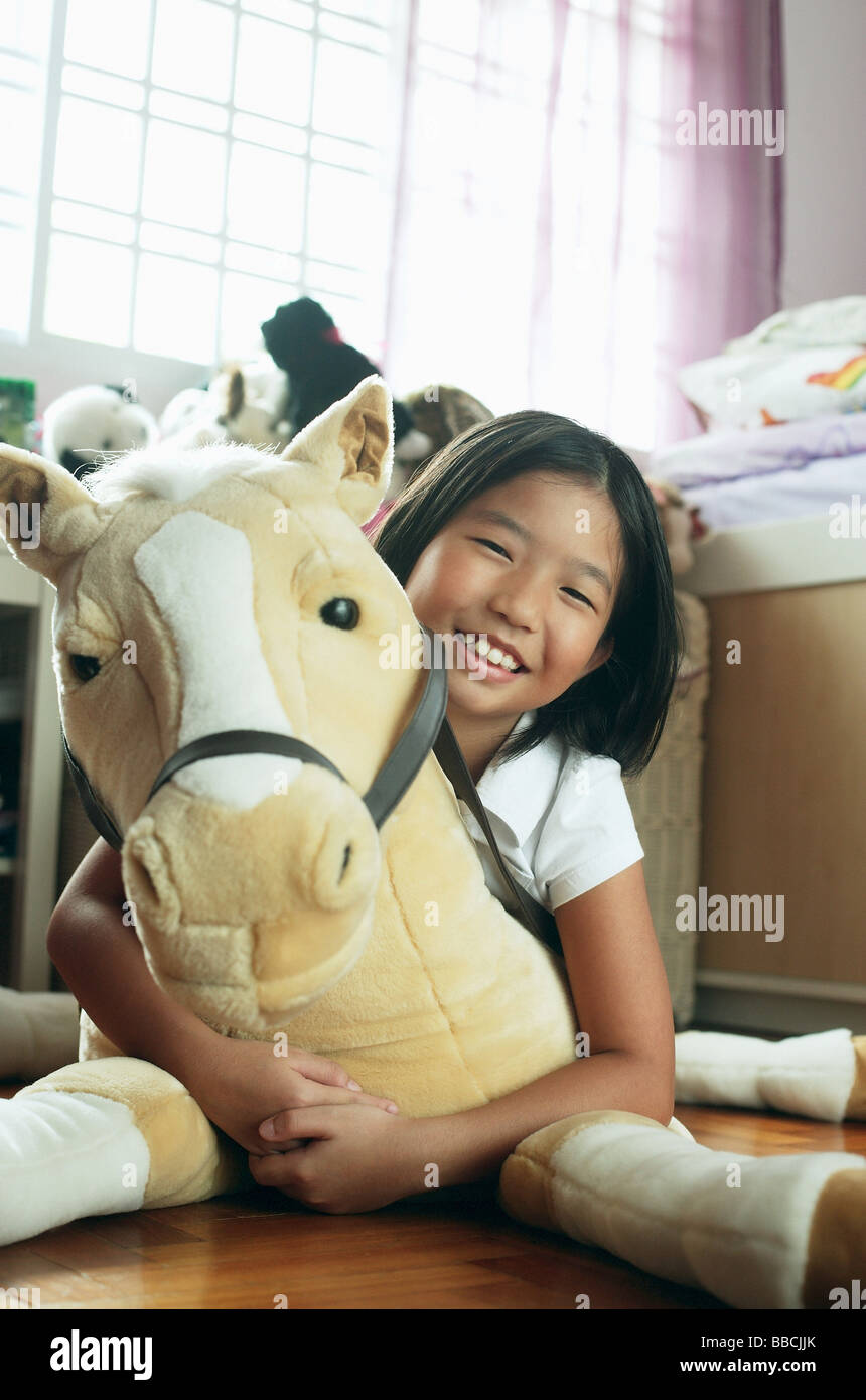 Girl in bedroom, hugging stuffed toy Stock Photo - Alamy