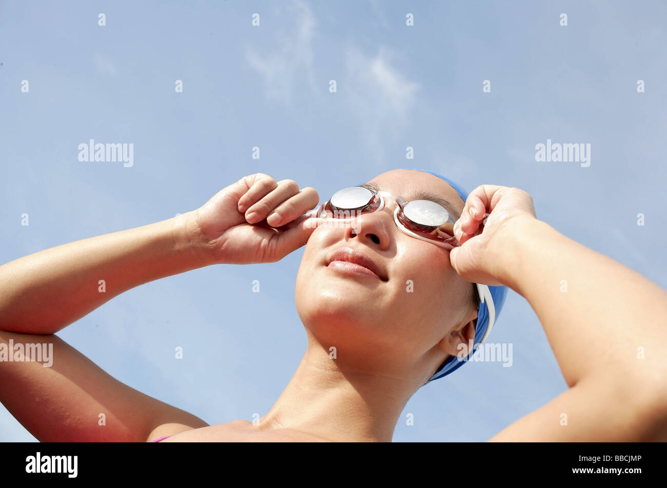 Woman adjusting swimming goggles Stock Photo - Alamy