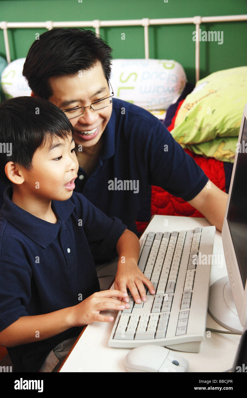 Father and son using computer Stock Photo - Alamy