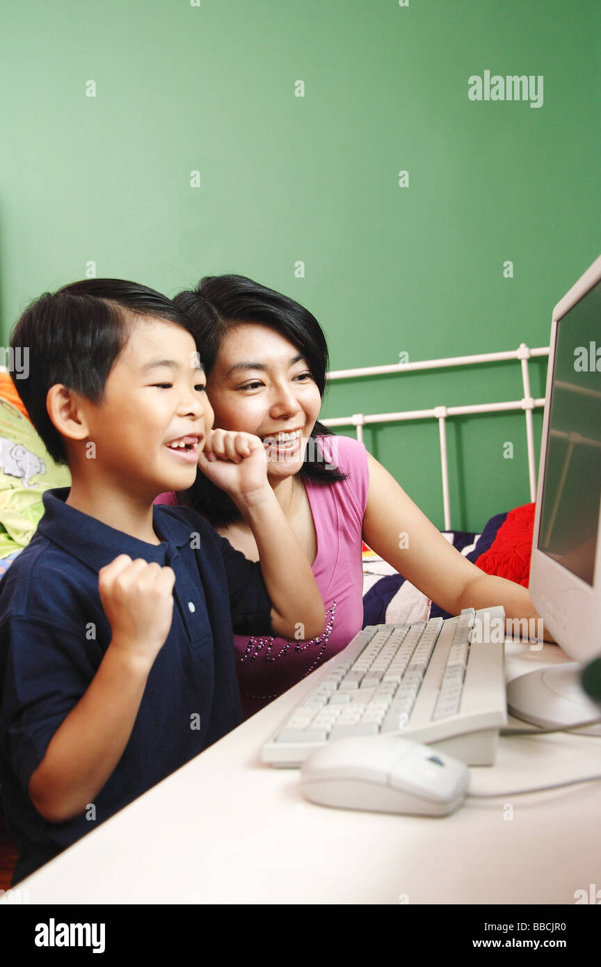 Mother and son looking at computer, smiling Stock Photo - Alamy