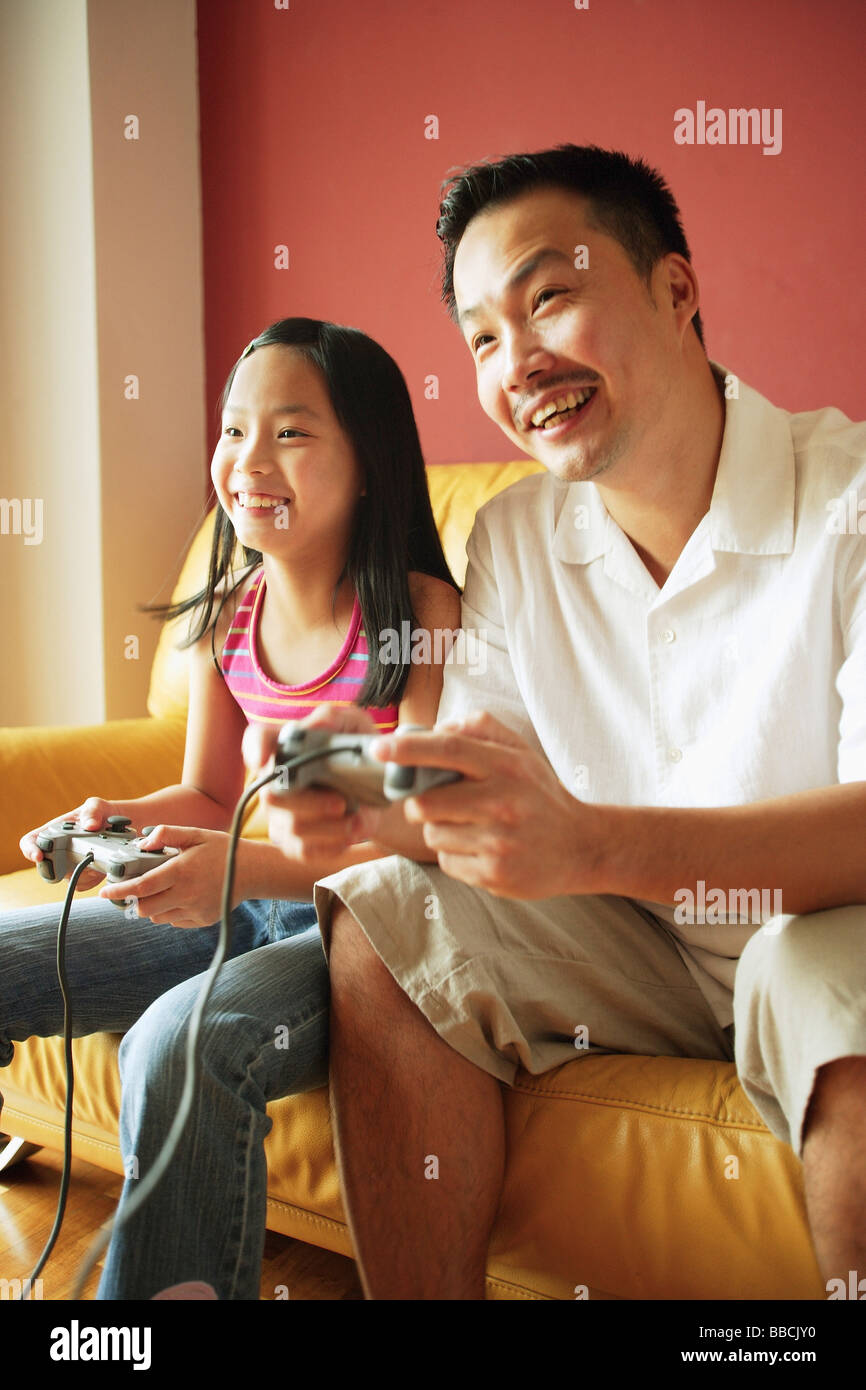 Father and daughter playing video games Stock Photo - Alamy