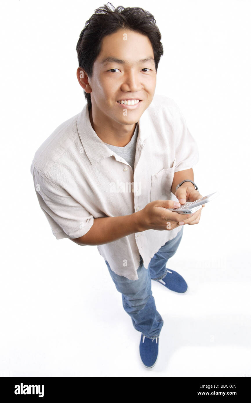 Young man holding mobile phone, looking up at camera Stock Photo - Alamy