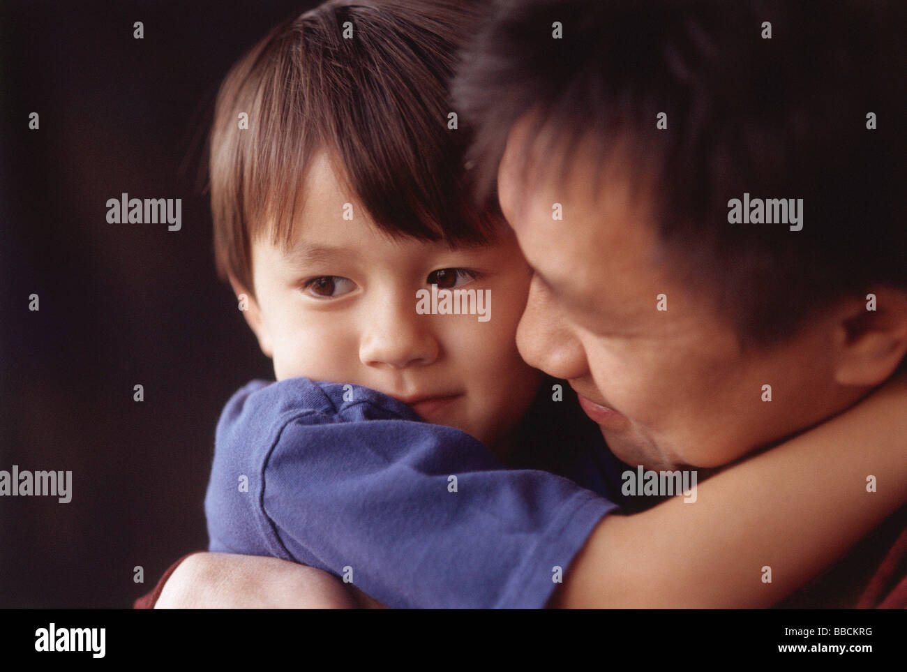 Young boy hugging his father Stock Photo - Alamy