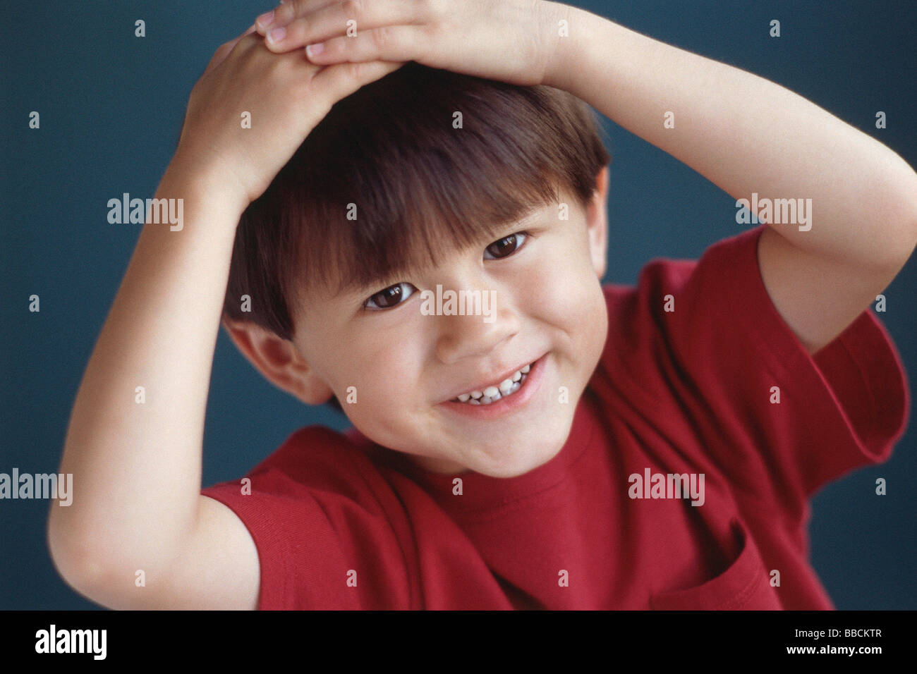Young boy smiling with hands on head Stock Photo - Alamy