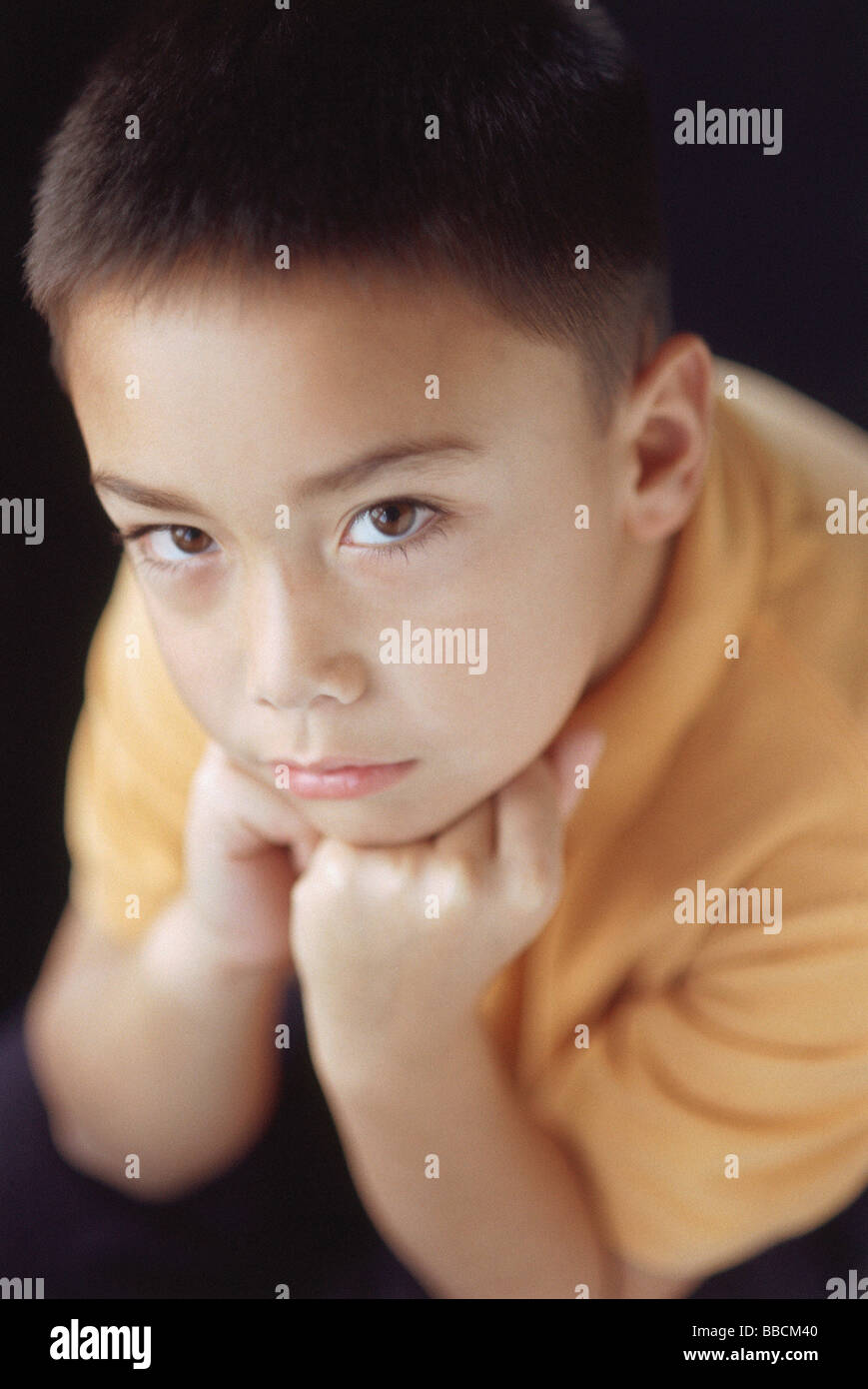 Boy with hand on chin Stock Photo - Alamy