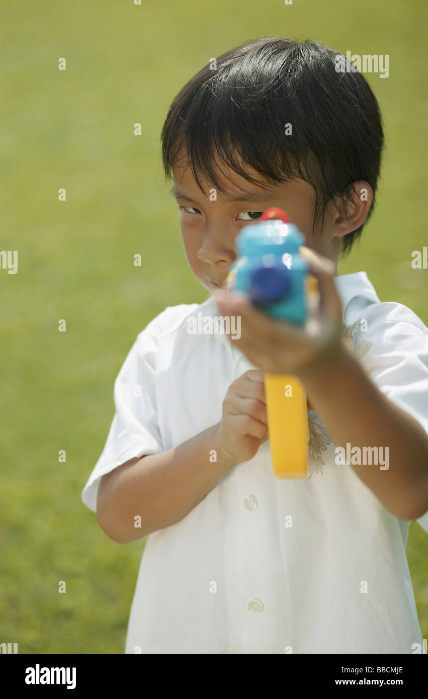Young boy playing with water gun Stock Photo - Alamy