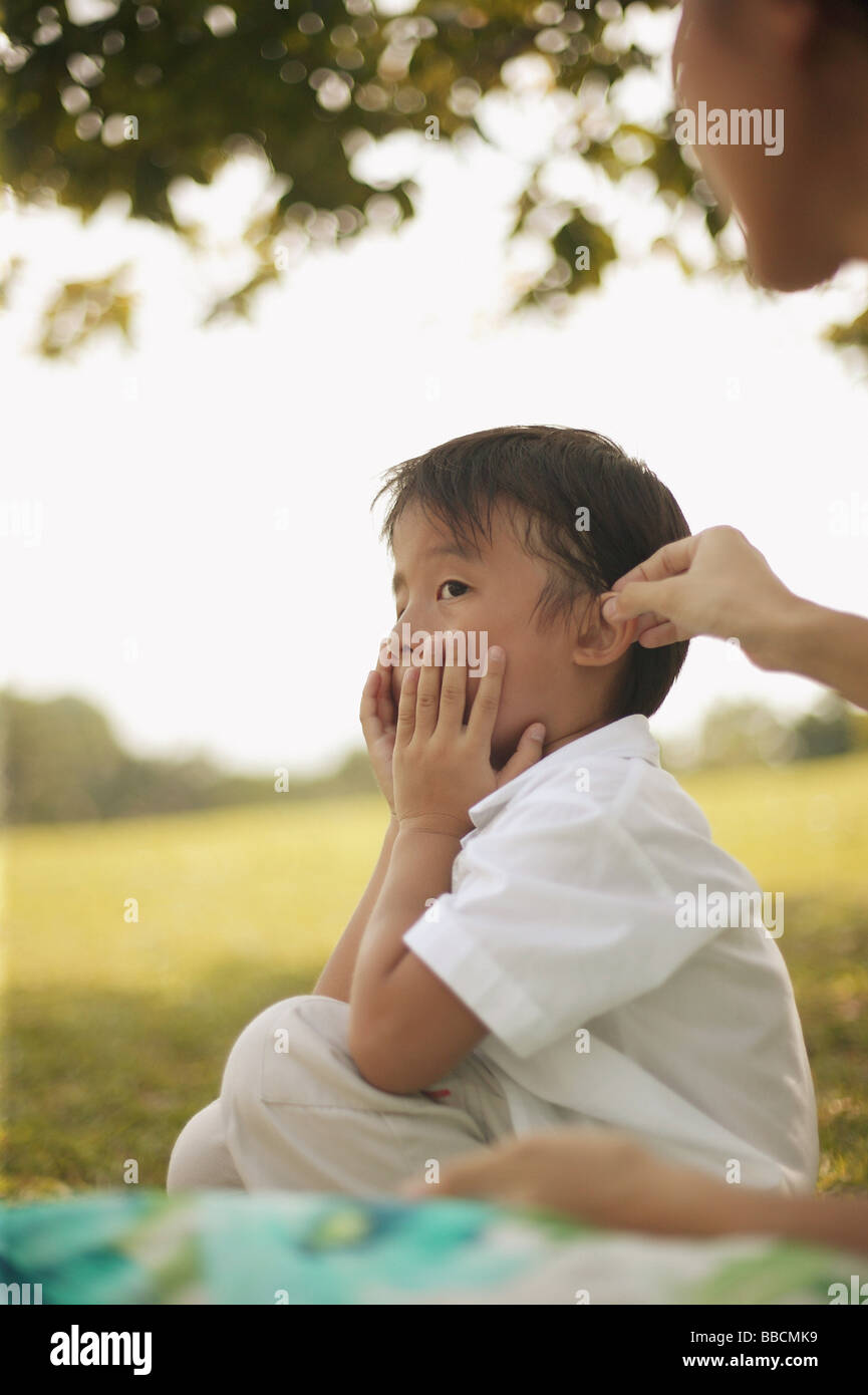 Young boy with hands on his face Stock Photo - Alamy
