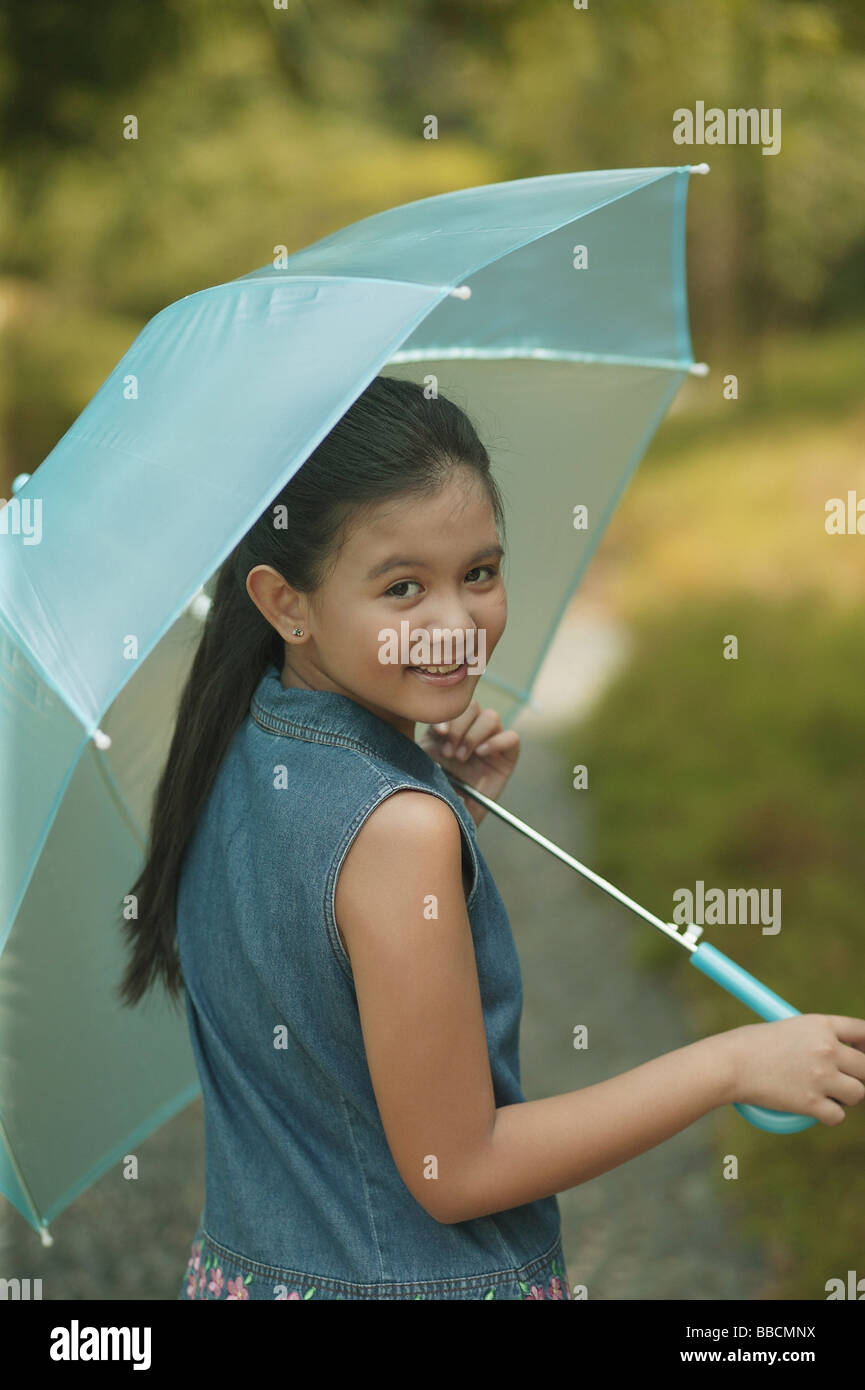 Young girl holding an umbrella, looking over shoulder Stock Photo - Alamy