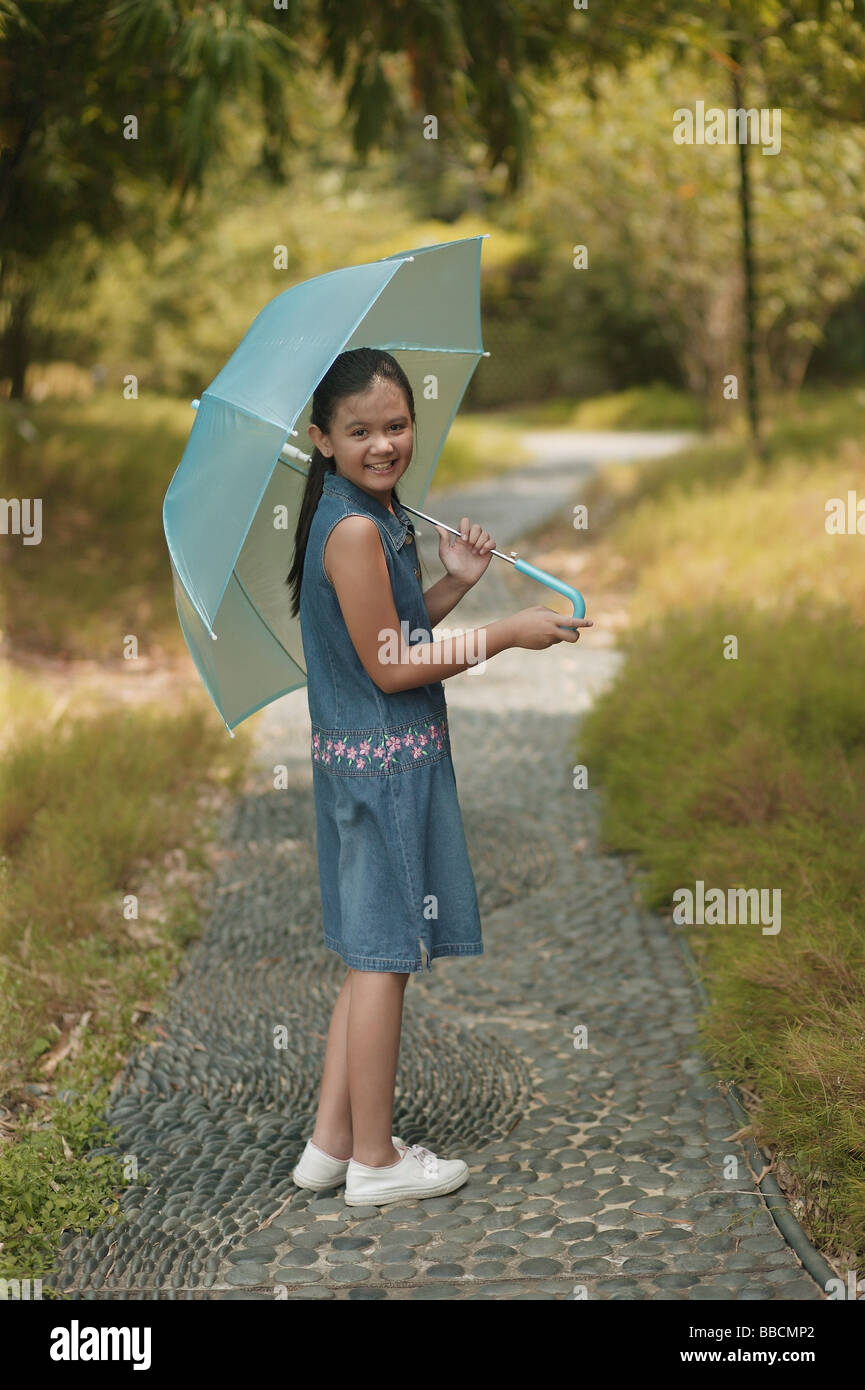 Young girl holding an umbrella, looking over shoulder Stock Photo - Alamy