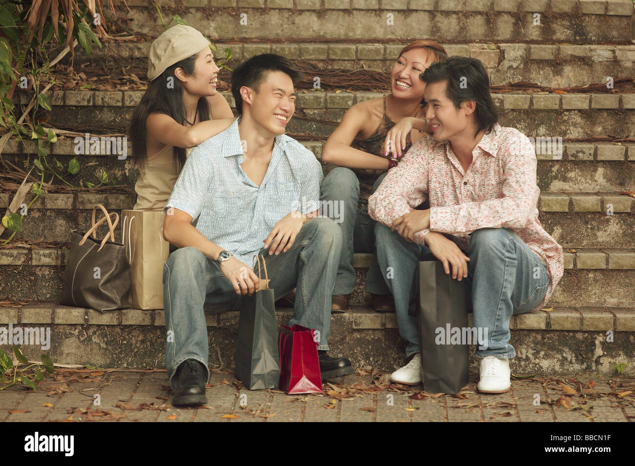 Couples sitting together on steps Stock Photo - Alamy