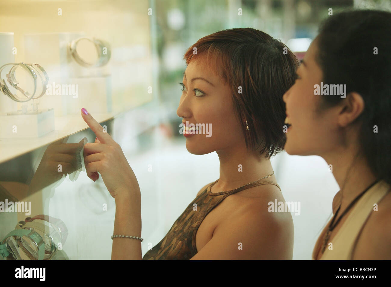 Two women in front of shop window Stock Photo - Alamy