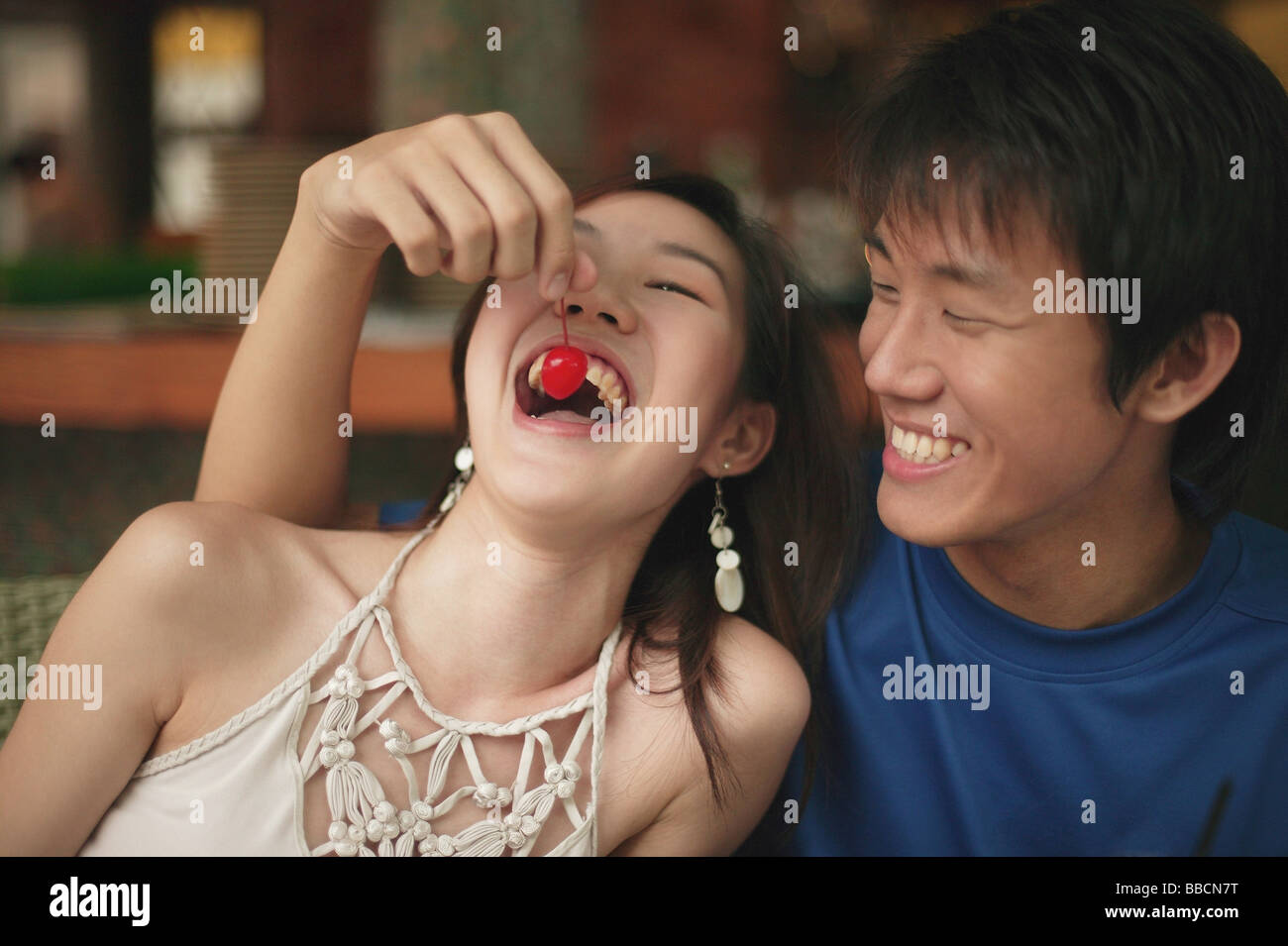 Young man feeding young woman a cherry Stock Photo - Alamy