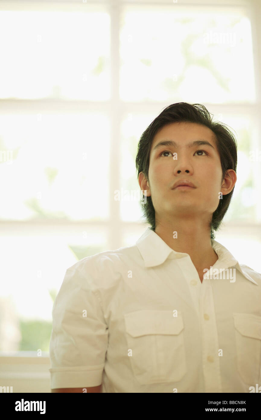 Young man standing and looking up Stock Photo - Alamy