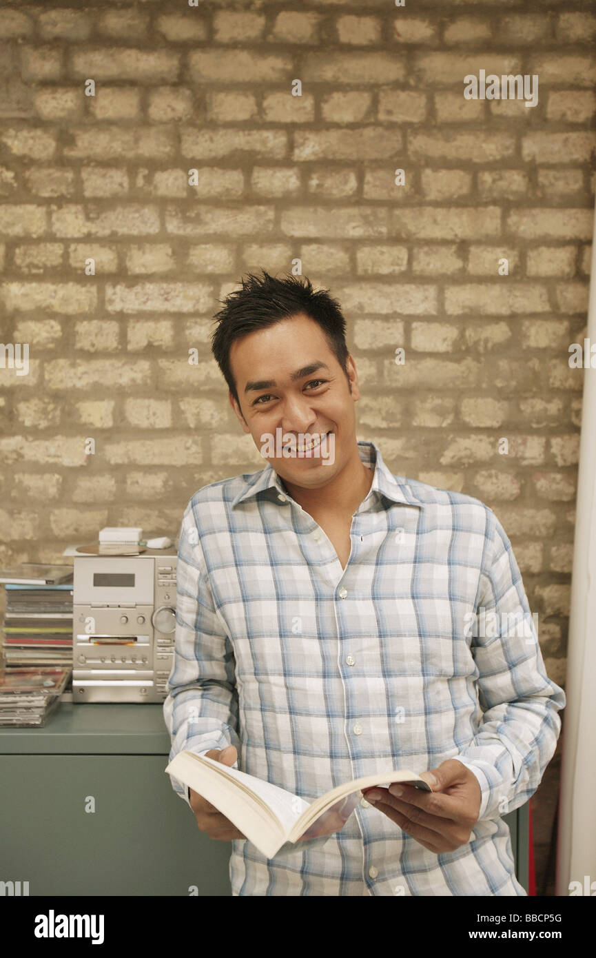 Man holding book, looking at camera Stock Photo - Alamy