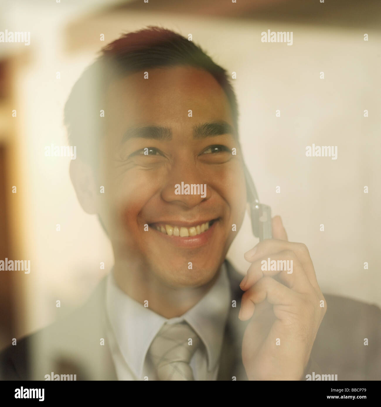 Businessman on mobile phone, smiling Stock Photo - Alamy
