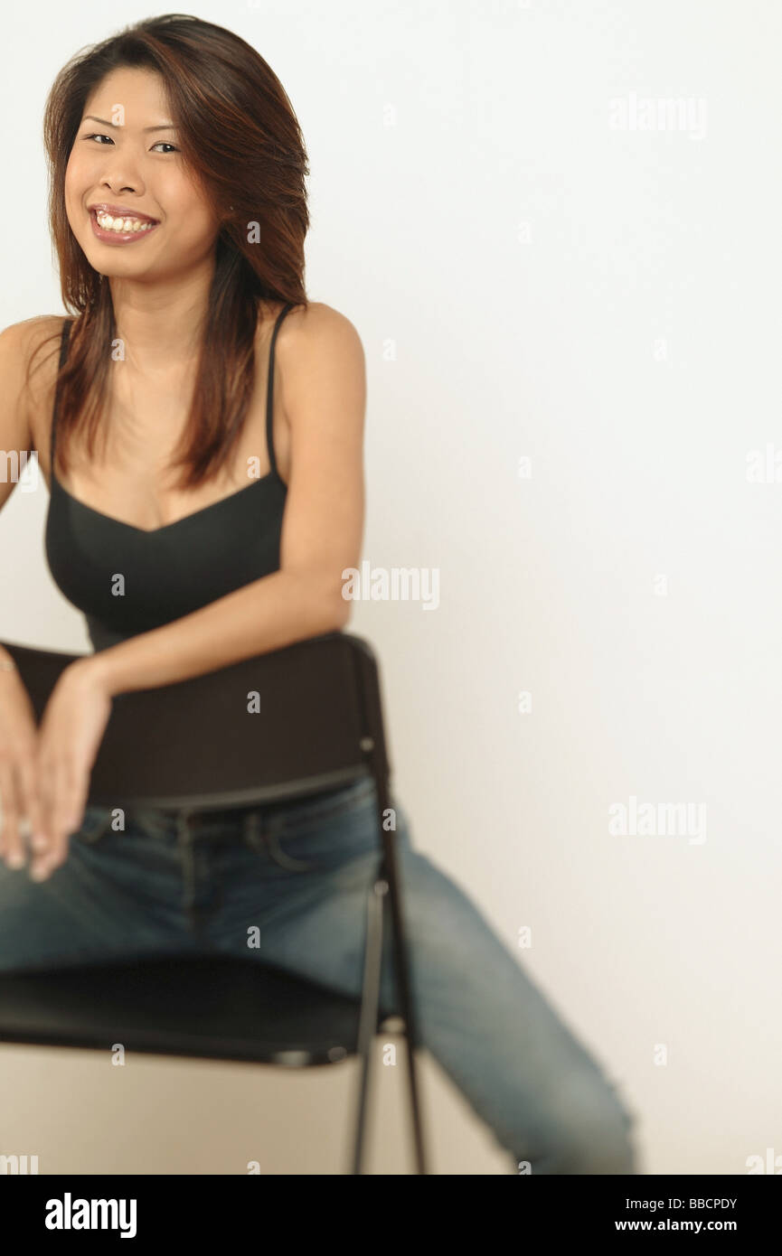 Young woman sitting down, looking at camera Stock Photo - Alamy