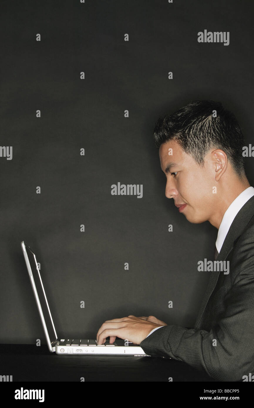 Young man using laptop, side view Stock Photo - Alamy