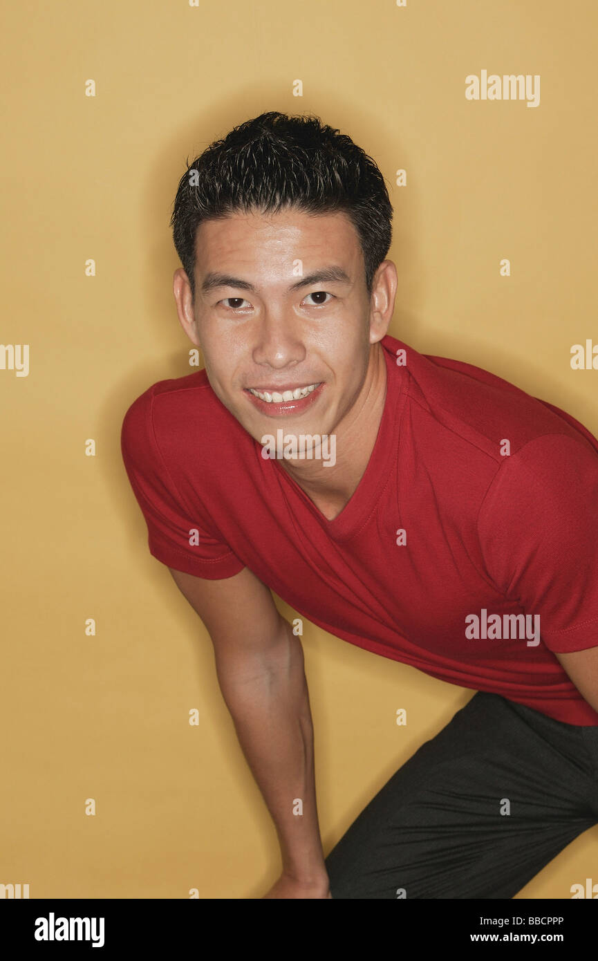 Young man leaning forward, smiling at camera Stock Photo - Alamy