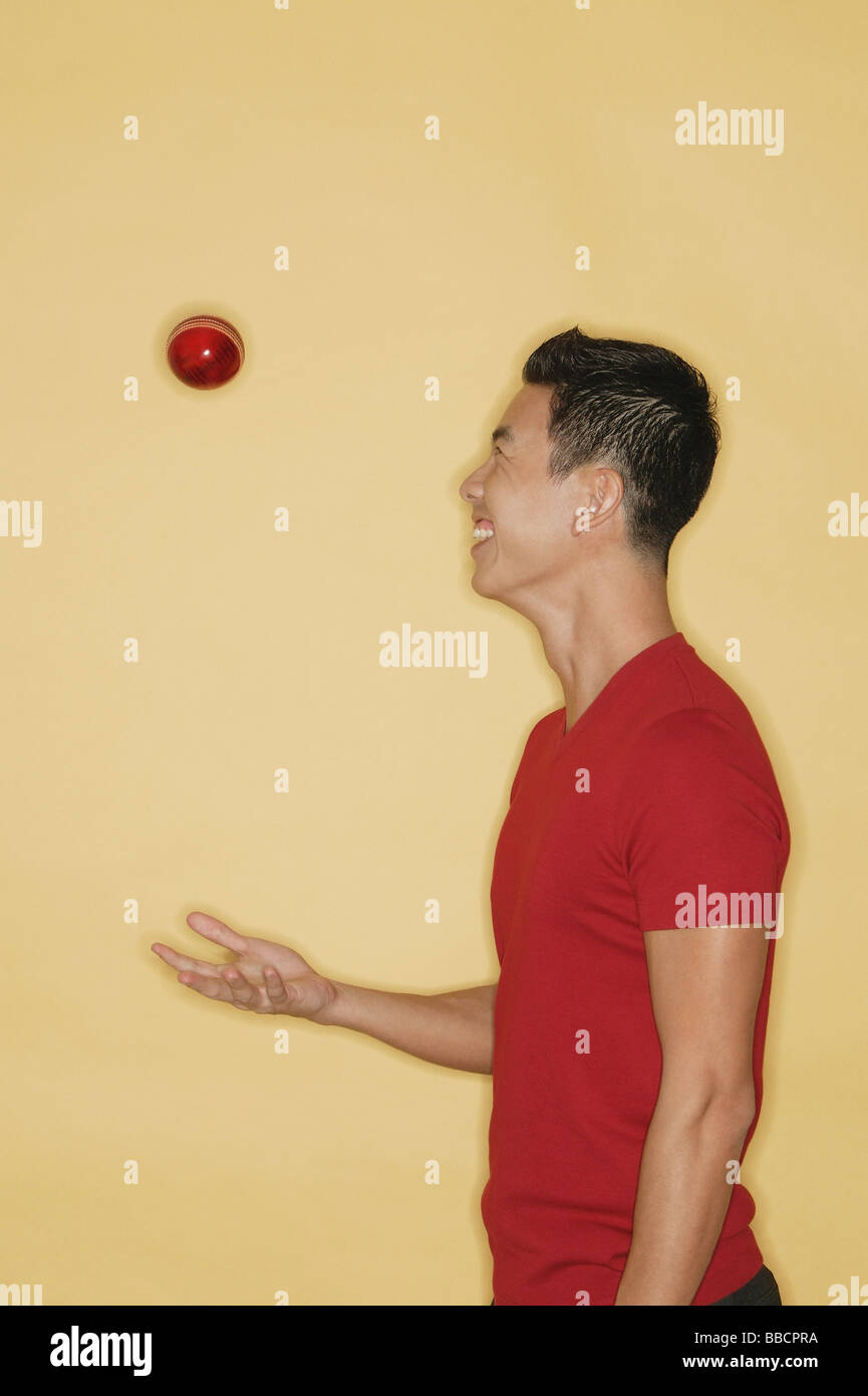 Young man juggling a ball, side view Stock Photo - Alamy