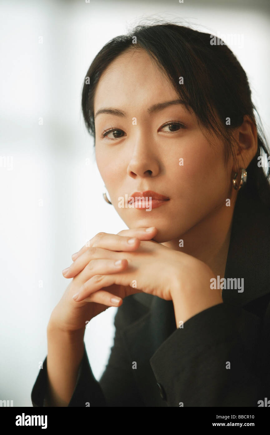 Young woman, hands on chin Stock Photo - Alamy