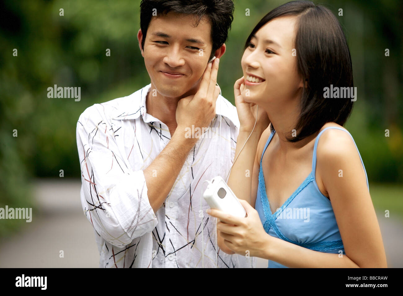 Couple listening to MP3 player Stock Photo - Alamy