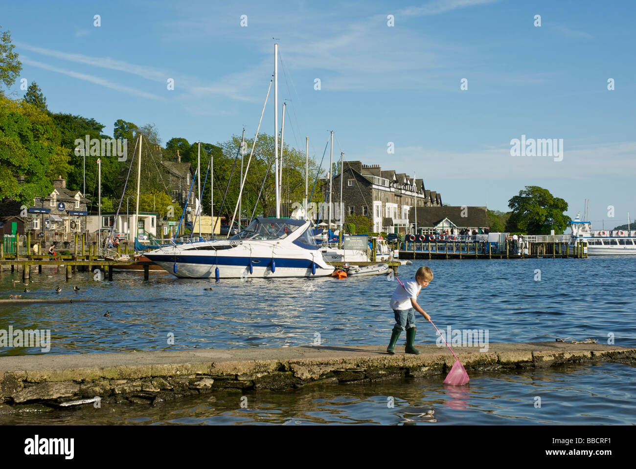 Boy on pier with fishing net, Lake Windermere at Waterhead, Lake ...