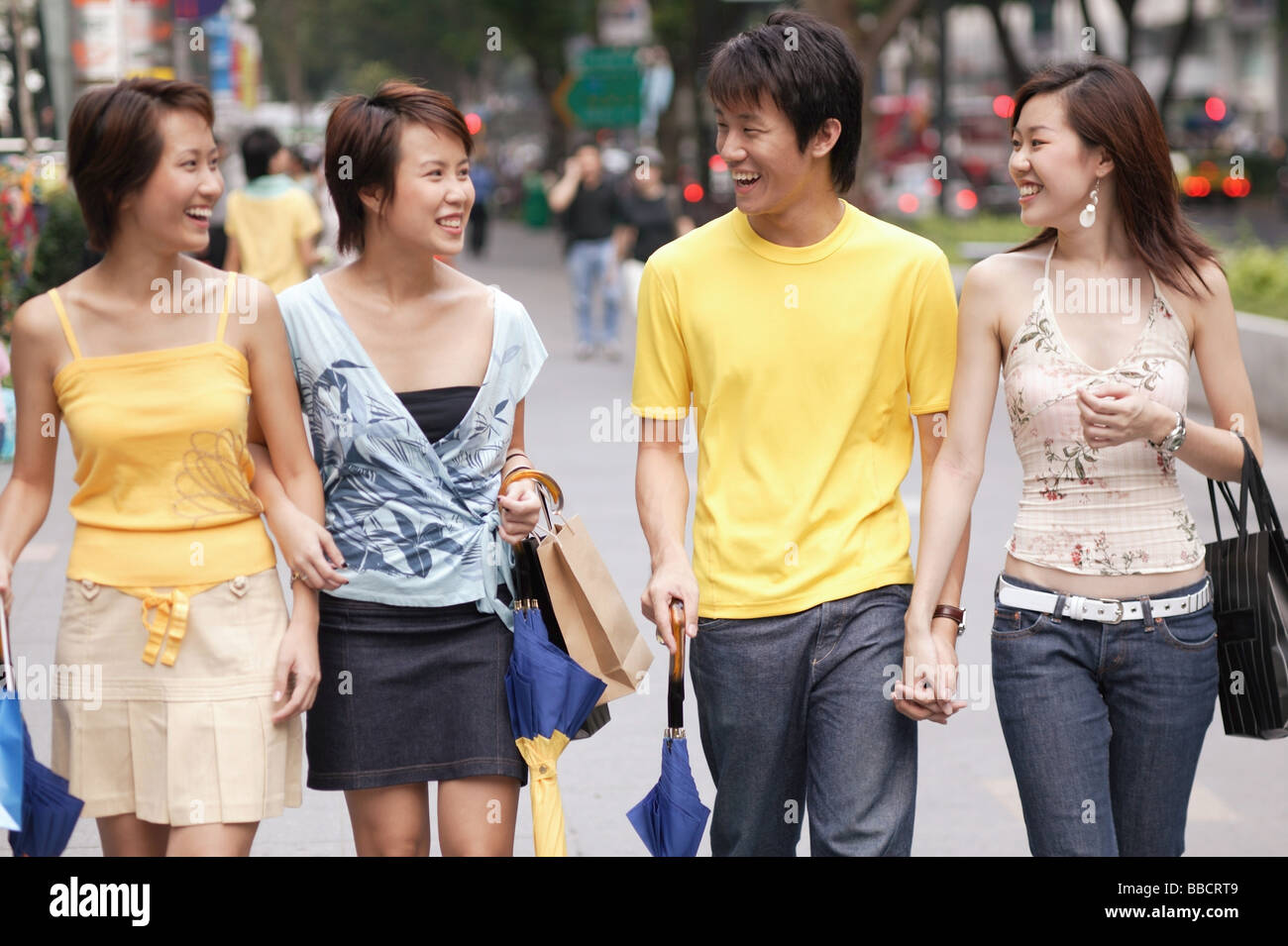 Friends walking side by side, talking Stock Photo - Alamy