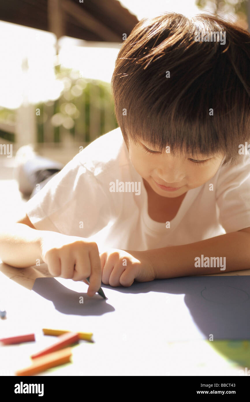 Young boy drawing with crayons Stock Photo - Alamy