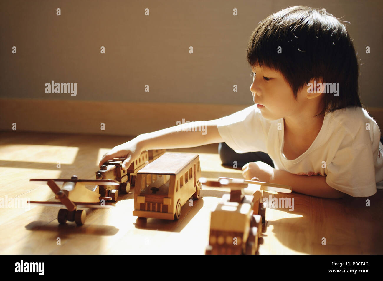 Young boy playing with toys, side view Stock Photo - Alamy