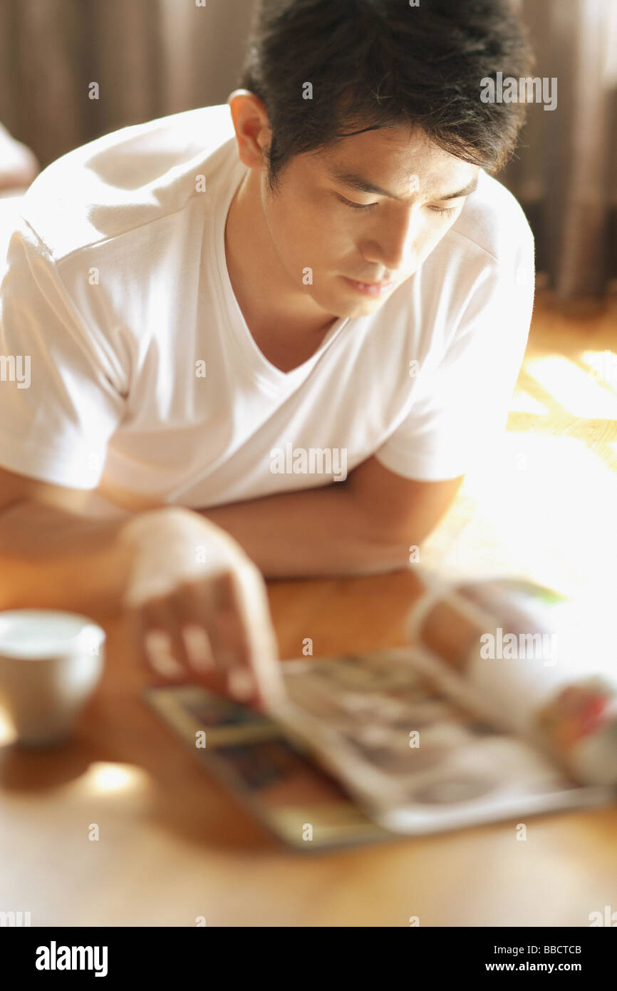 Young man reading magazine Stock Photo - Alamy