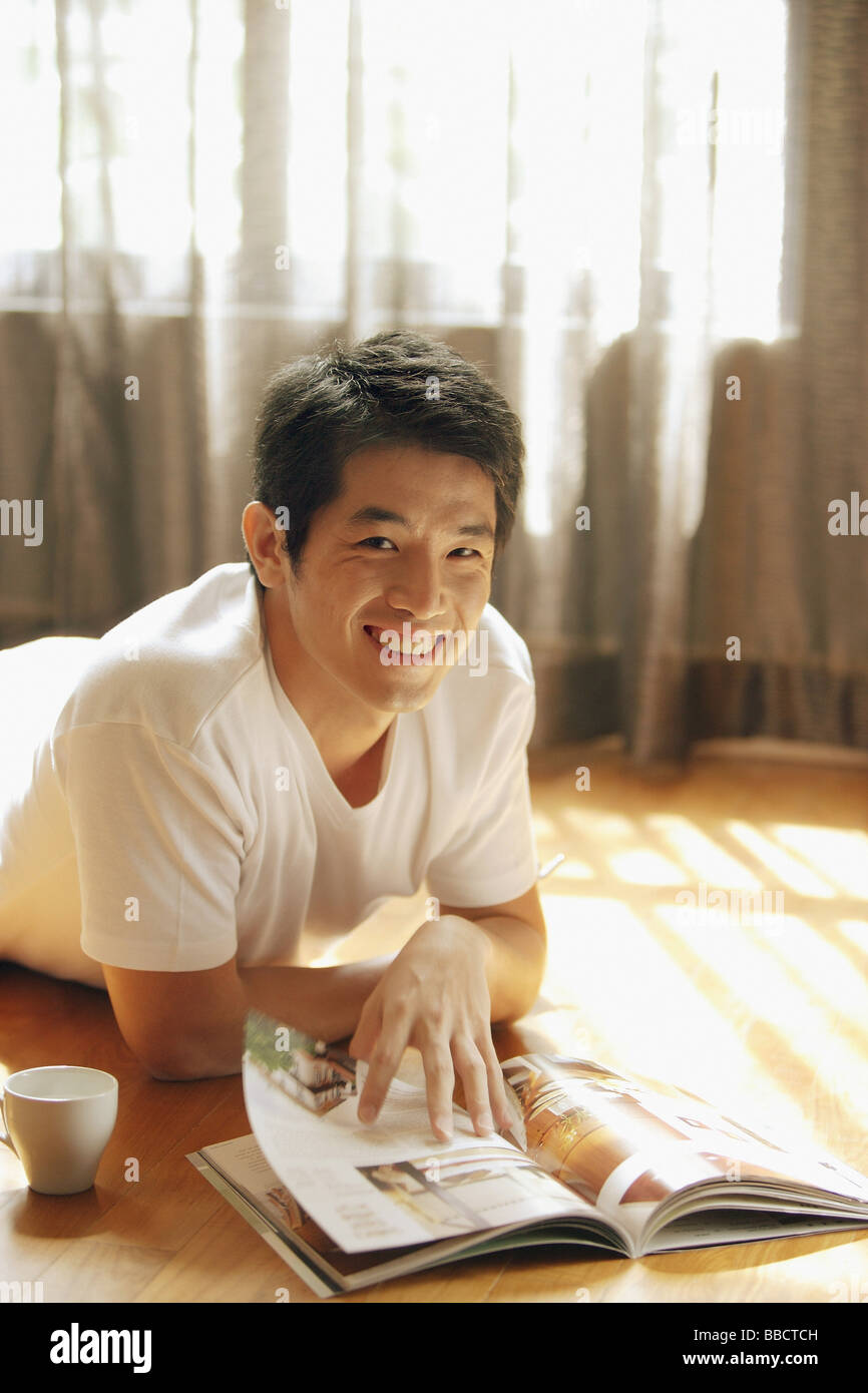 Young man with magazine, looking at camera Stock Photo - Alamy