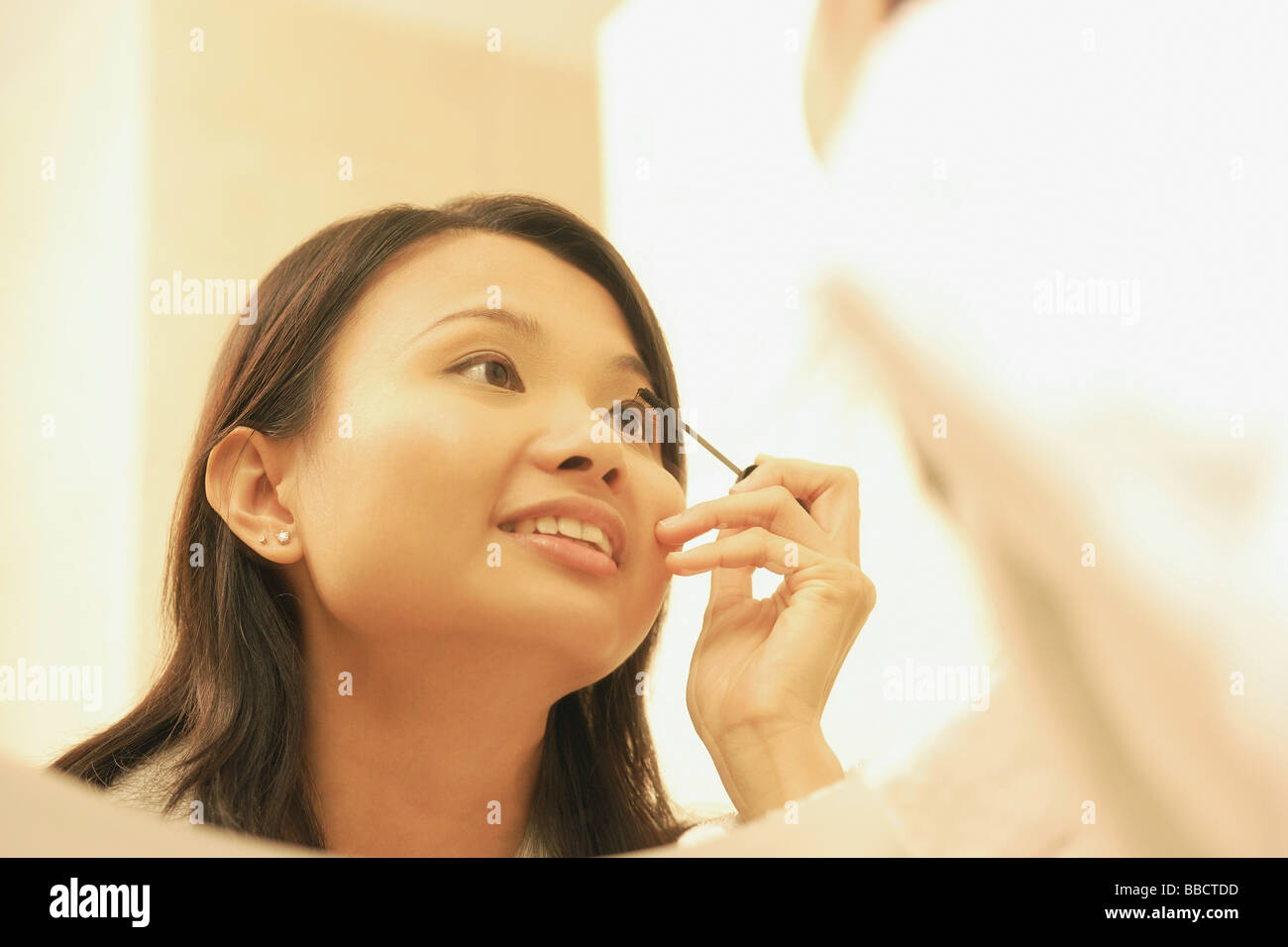 Woman putting on mascara Stock Photo - Alamy