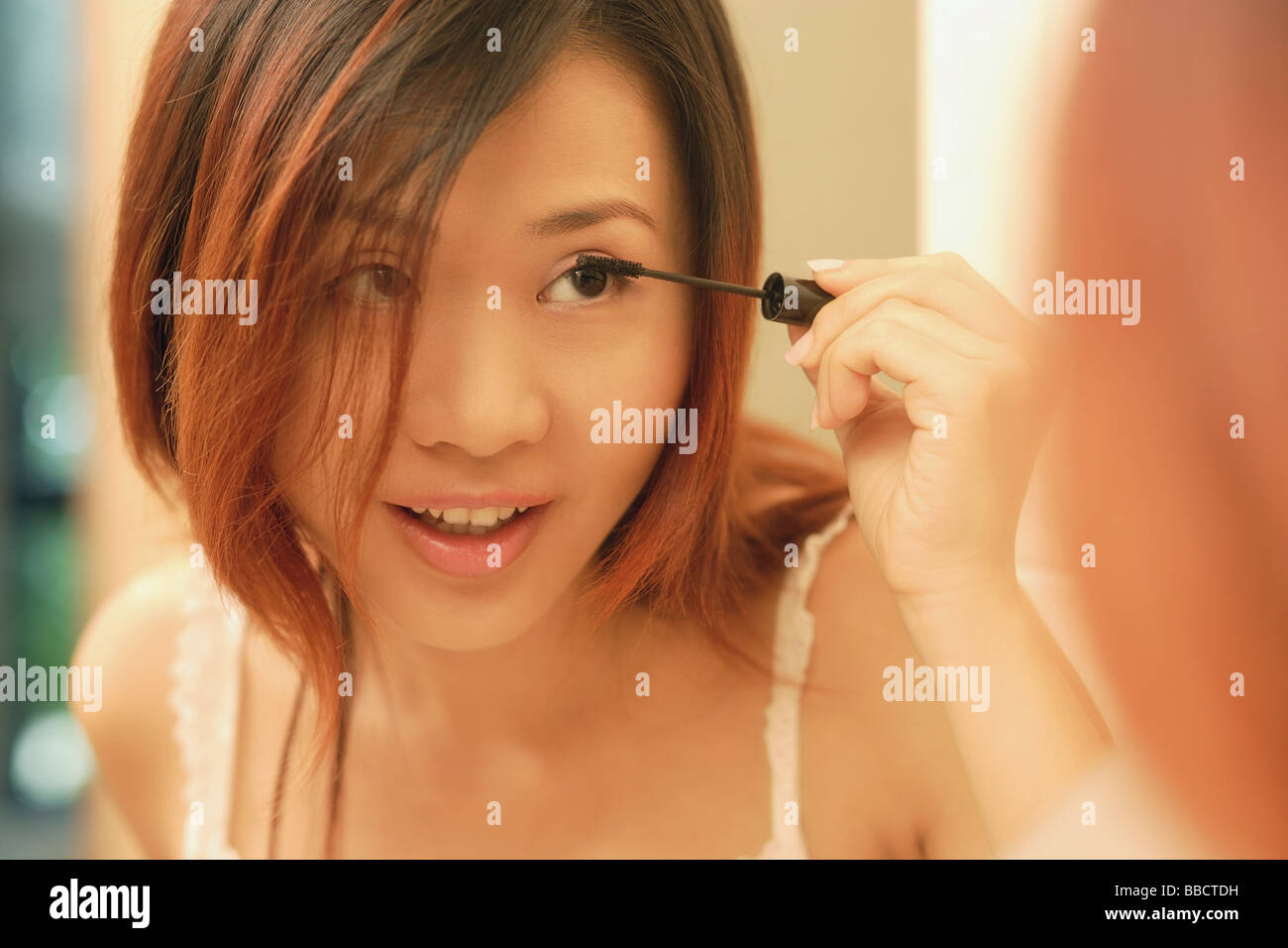 Woman putting on mascara Stock Photo - Alamy