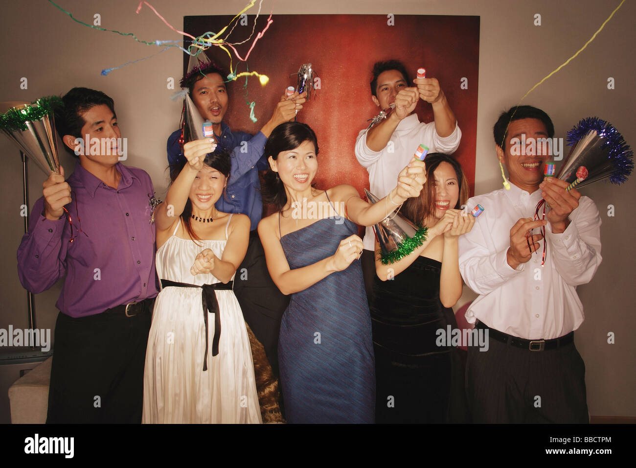 Group of friends having a party at home, playing with streamers and ...