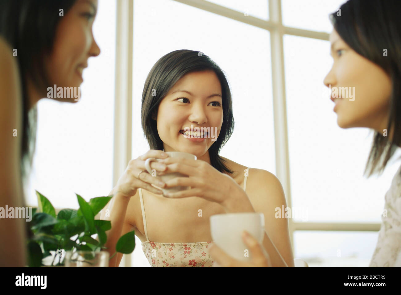 Sisters sitting, having coffee and talking Stock Photo - Alamy