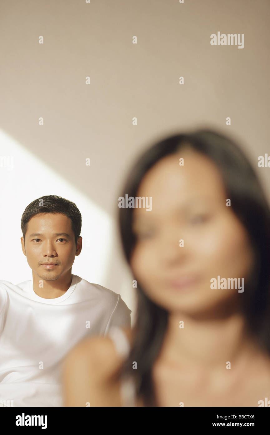 Young man looking at camera, woman in front of him Stock Photo - Alamy