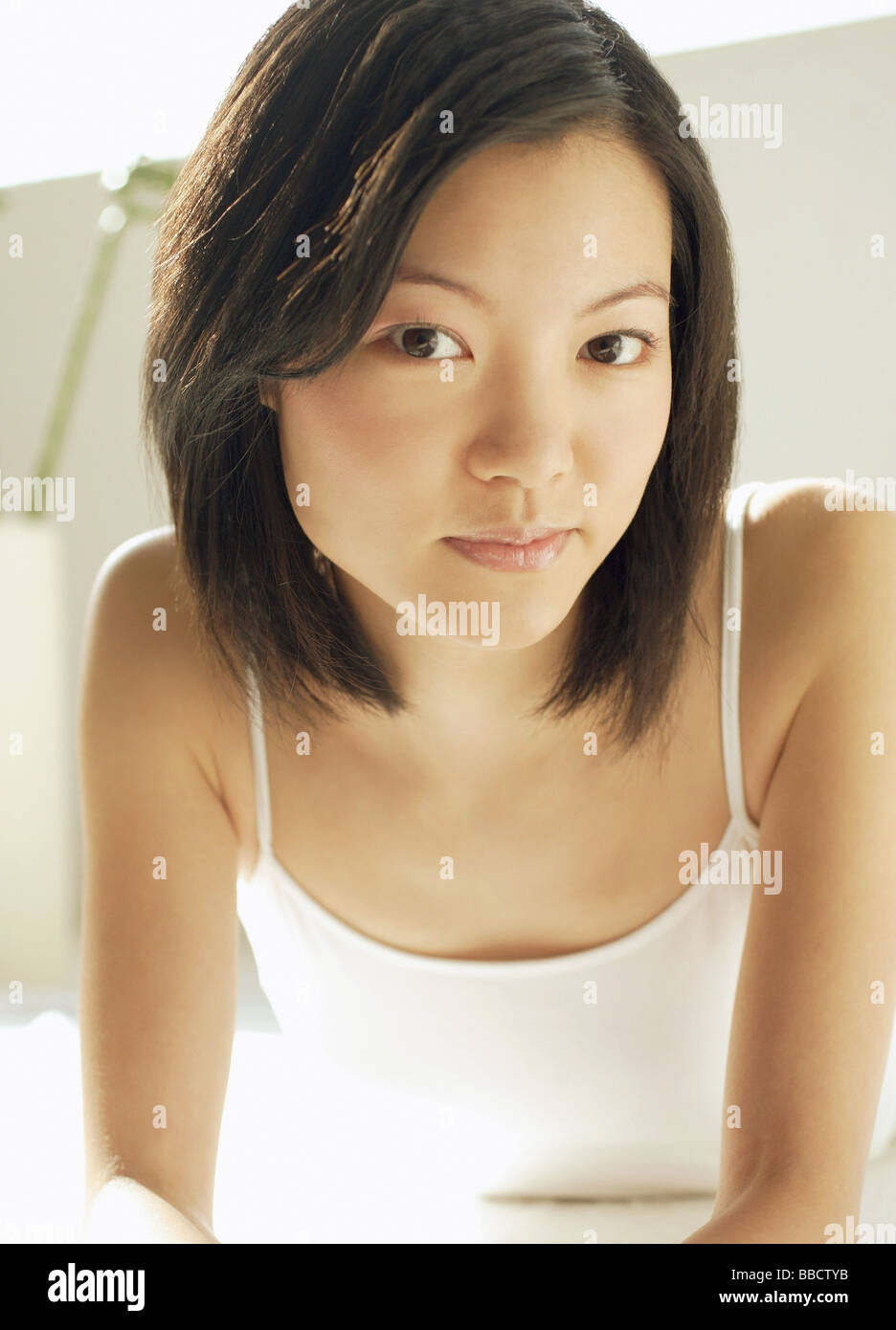 Young woman lying on front, looking at camera Stock Photo - Alamy