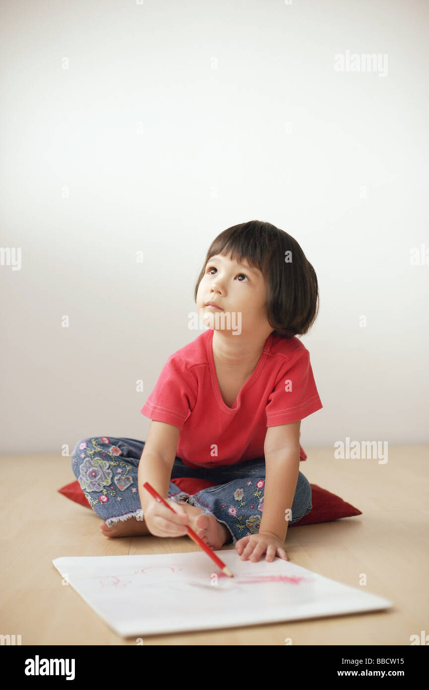 Young girl drawing on drawing pad, looking up Stock Photo - Alamy