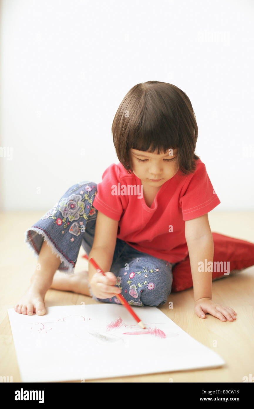 Young girl drawing on drawing pad, sitting on floor Stock Photo - Alamy
