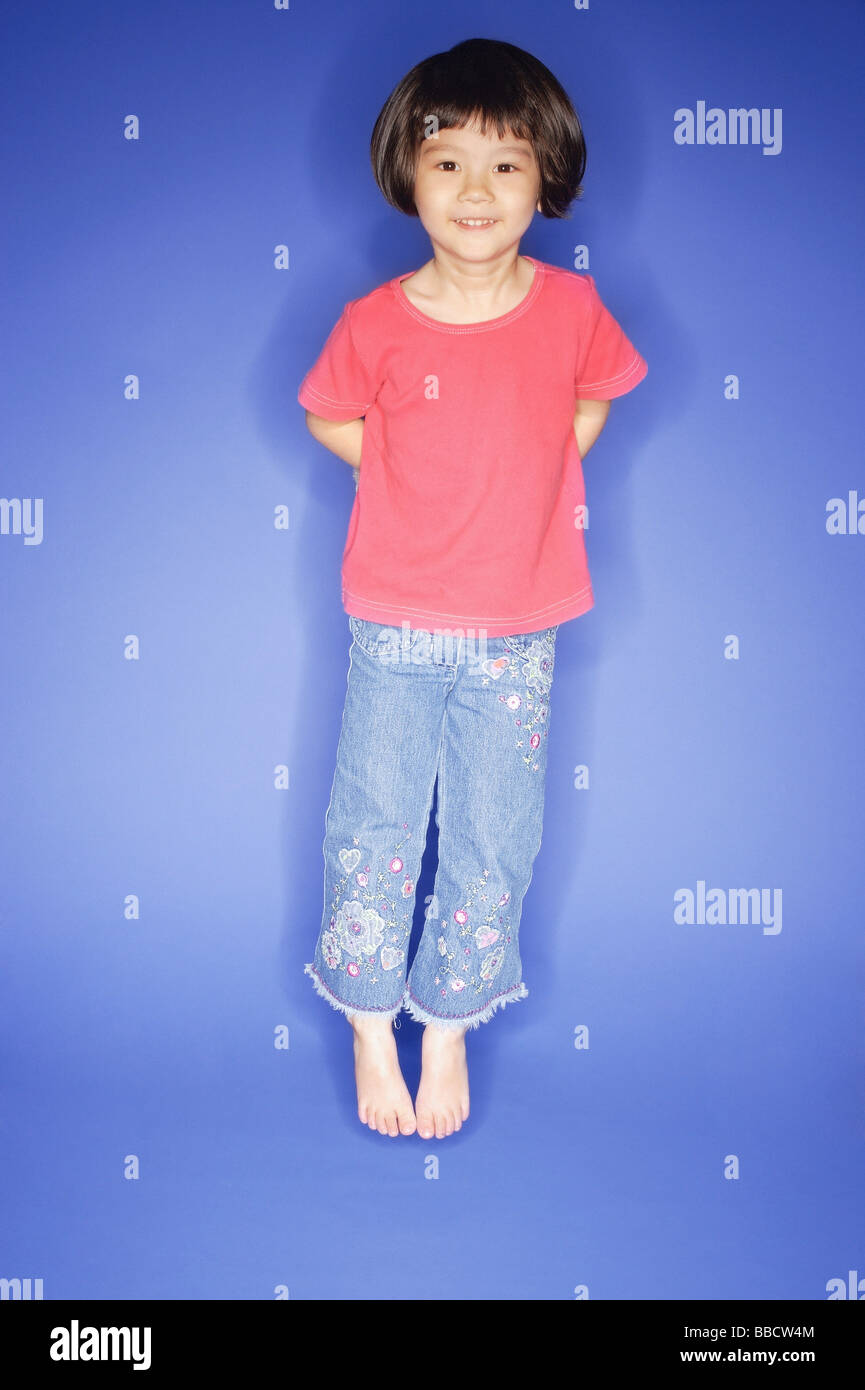 Young girl jumping, blue background Stock Photo - Alamy