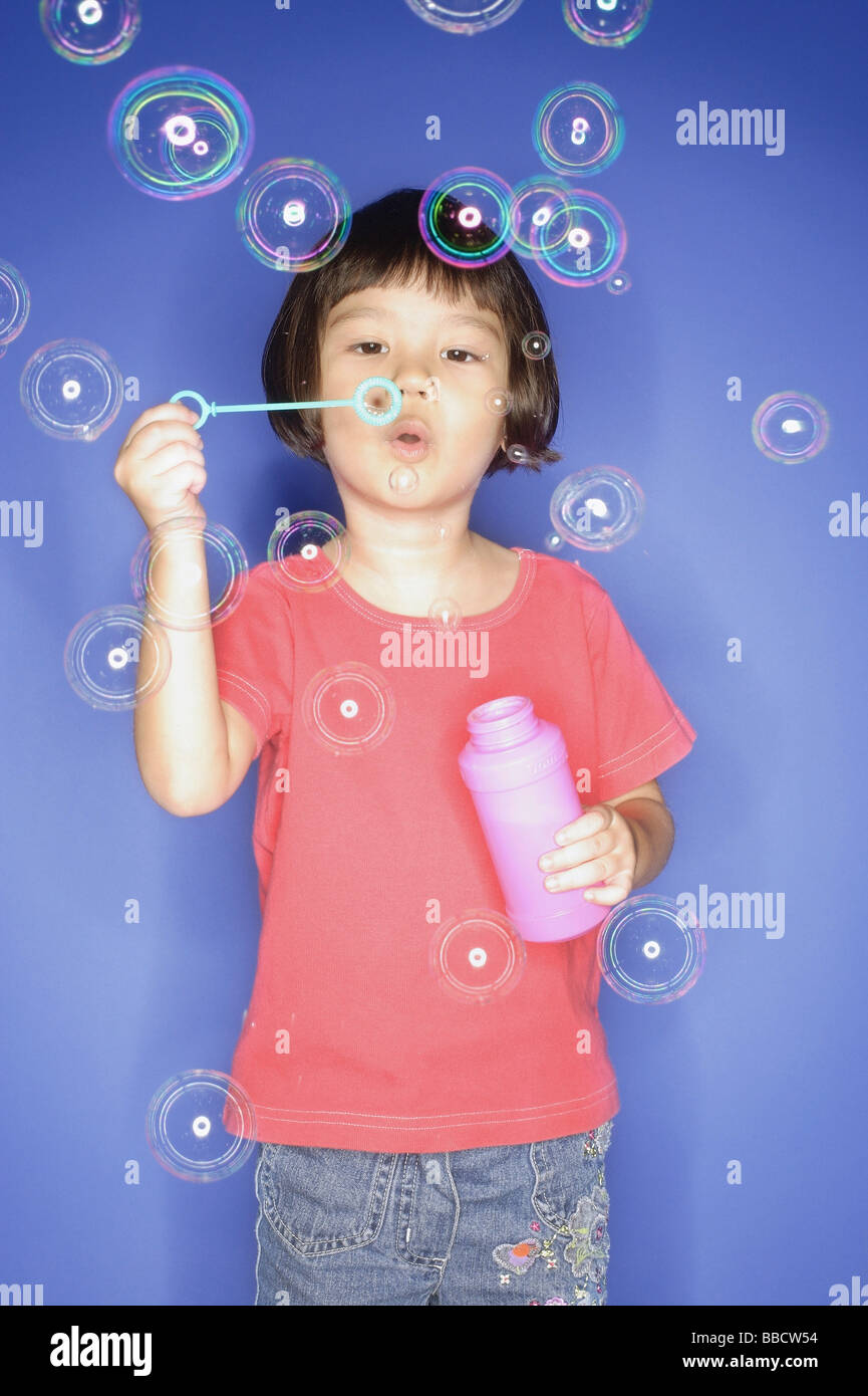 Young girl blowing bubbles from bubble wand Stock Photo - Alamy