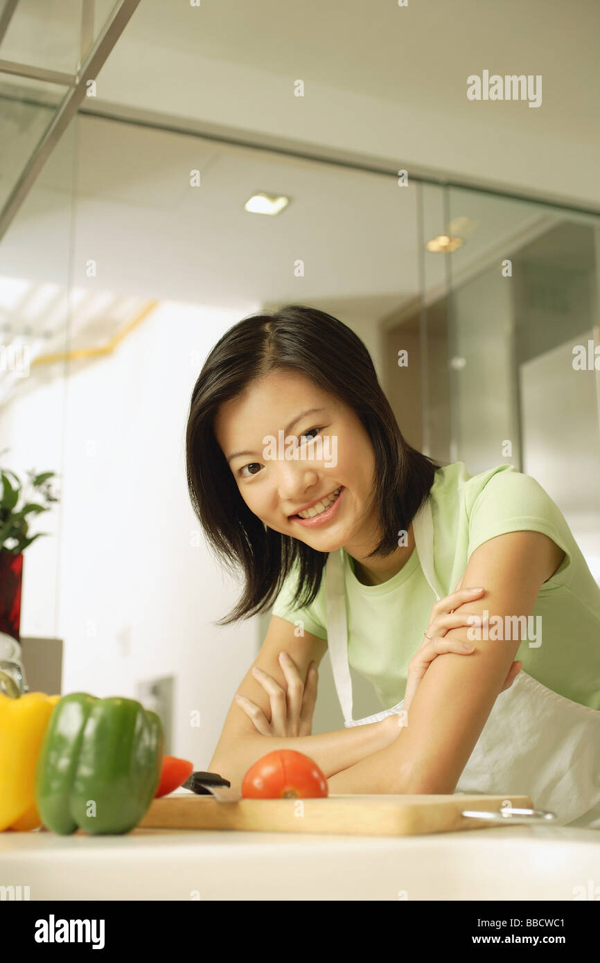 Young woman leaning on kitchen counter, arms crossed Stock Photo - Alamy