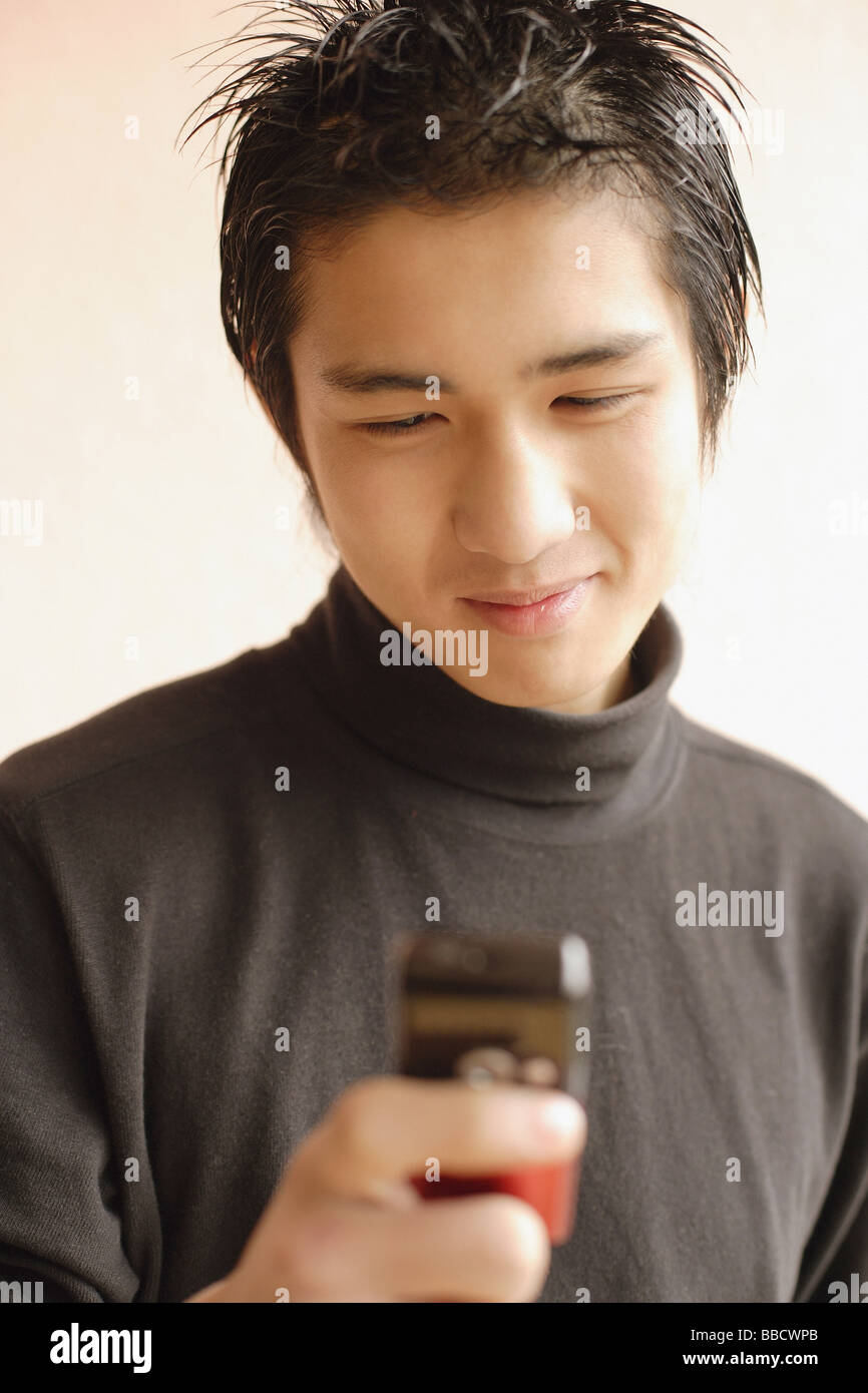 Young man using mobile phone, smiling Stock Photo - Alamy