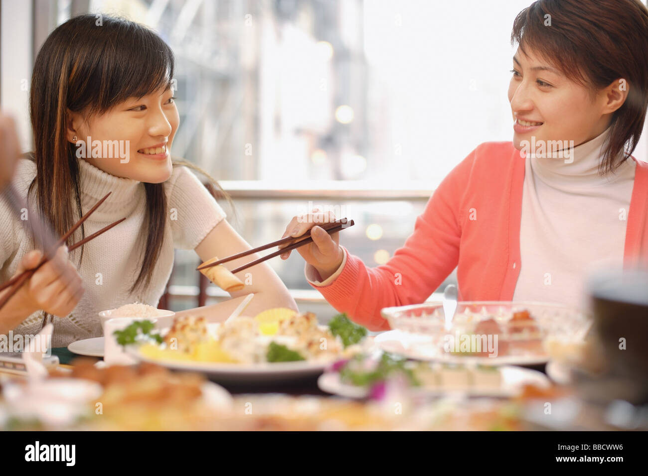 Young women eating at Chinese restaurant, side by side Stock Photo - Alamy