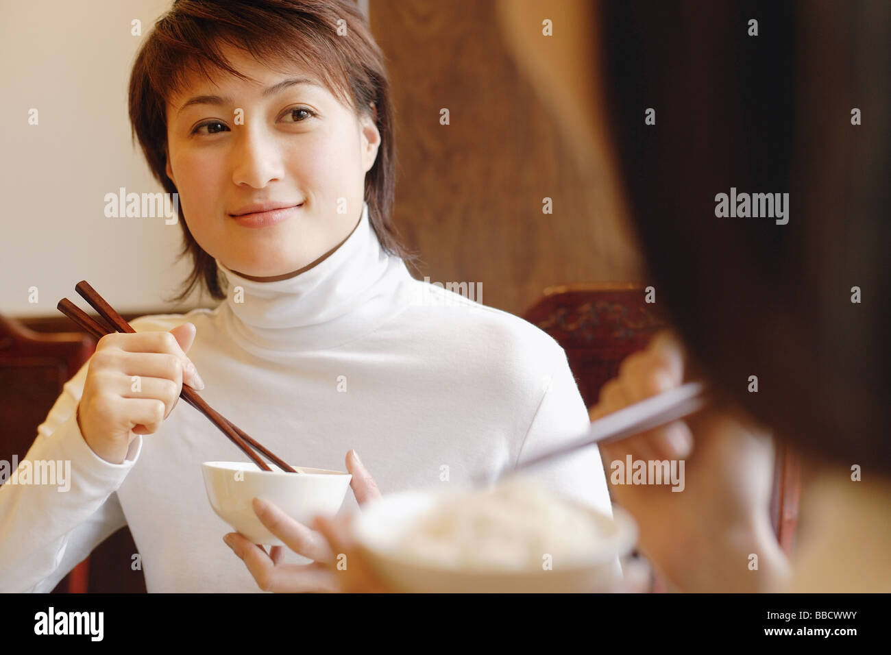 Young women eating rice at a Chinese restaurant Stock Photo - Alamy