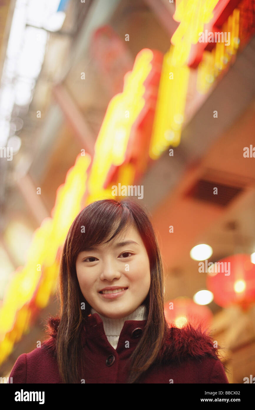 Young woman looking at camera, neon signs behind her Stock Photo - Alamy