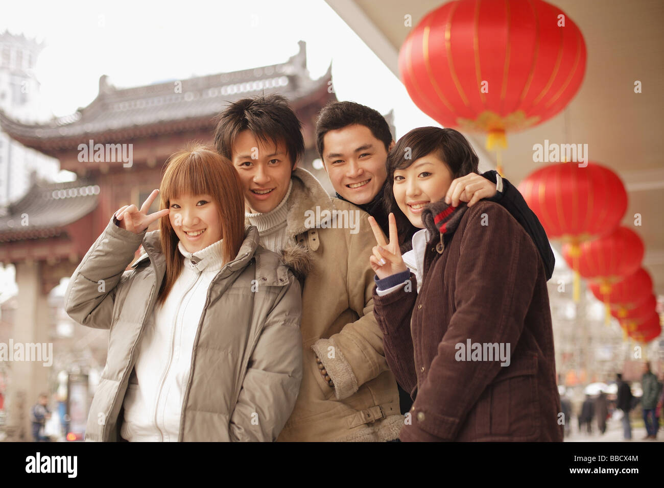Couples posing, looking at camera, making peace signs Stock Photo - Alamy