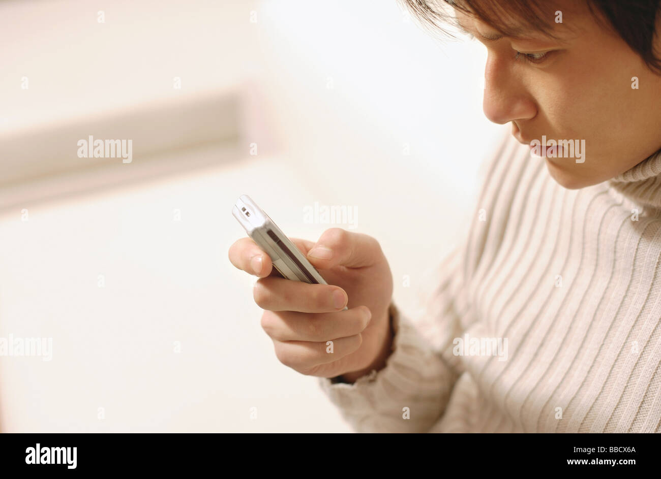 Young man sitting, using mobile phone Stock Photo - Alamy